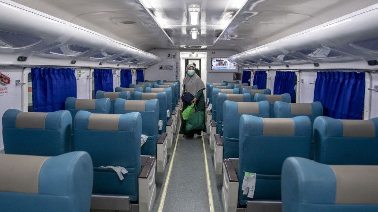 Penumpang kereta api berjalan di dalam gerbong Kereta Api Singasari, di ...