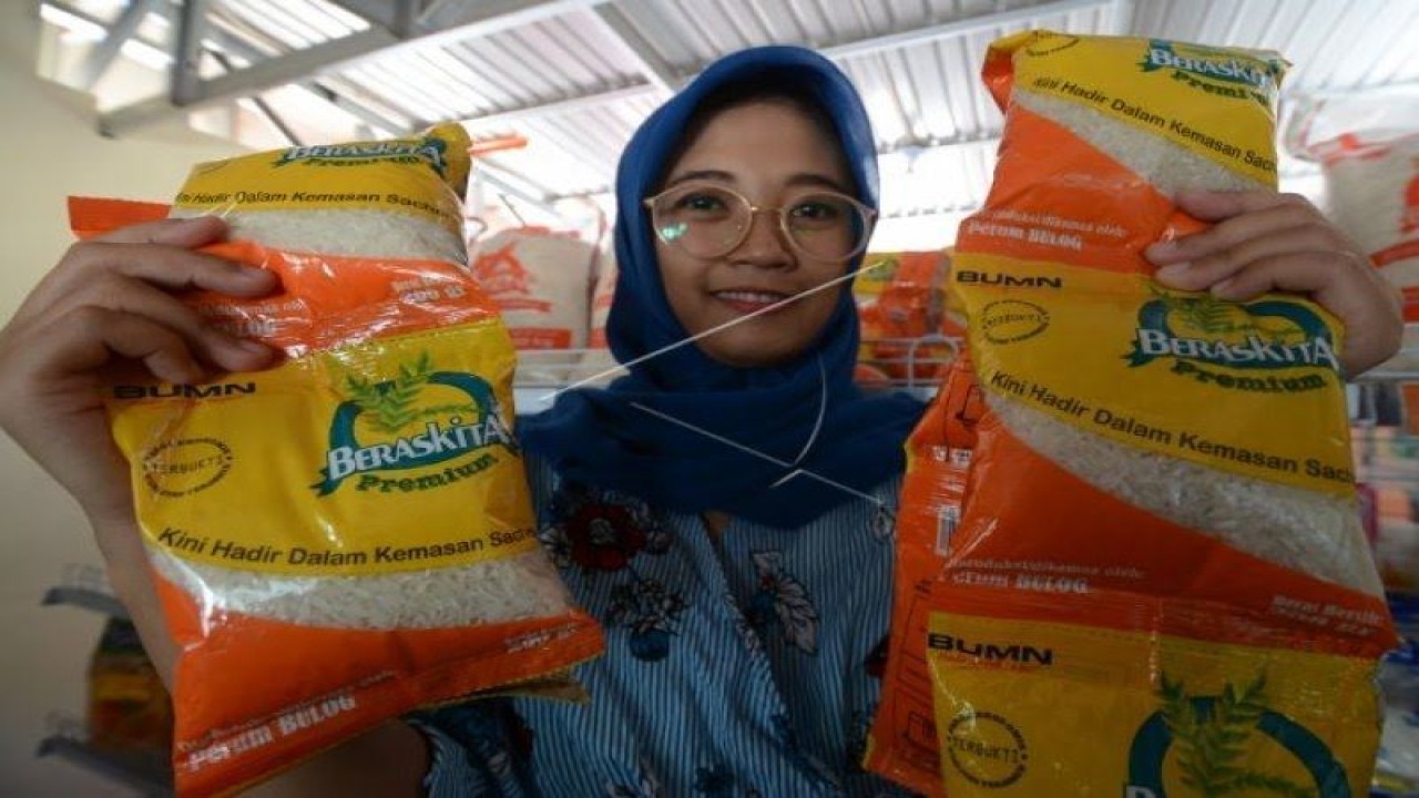 Petugas Bulog menunjukkan beras dalam kemasan sachet ukuran 200 gram untuk dijual di Rumah ...