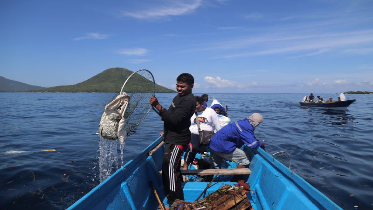 Warga mengangkut sampah saat aksi bersih sampah laut di perairan Ternate, Kota Ternate Maluku ...
